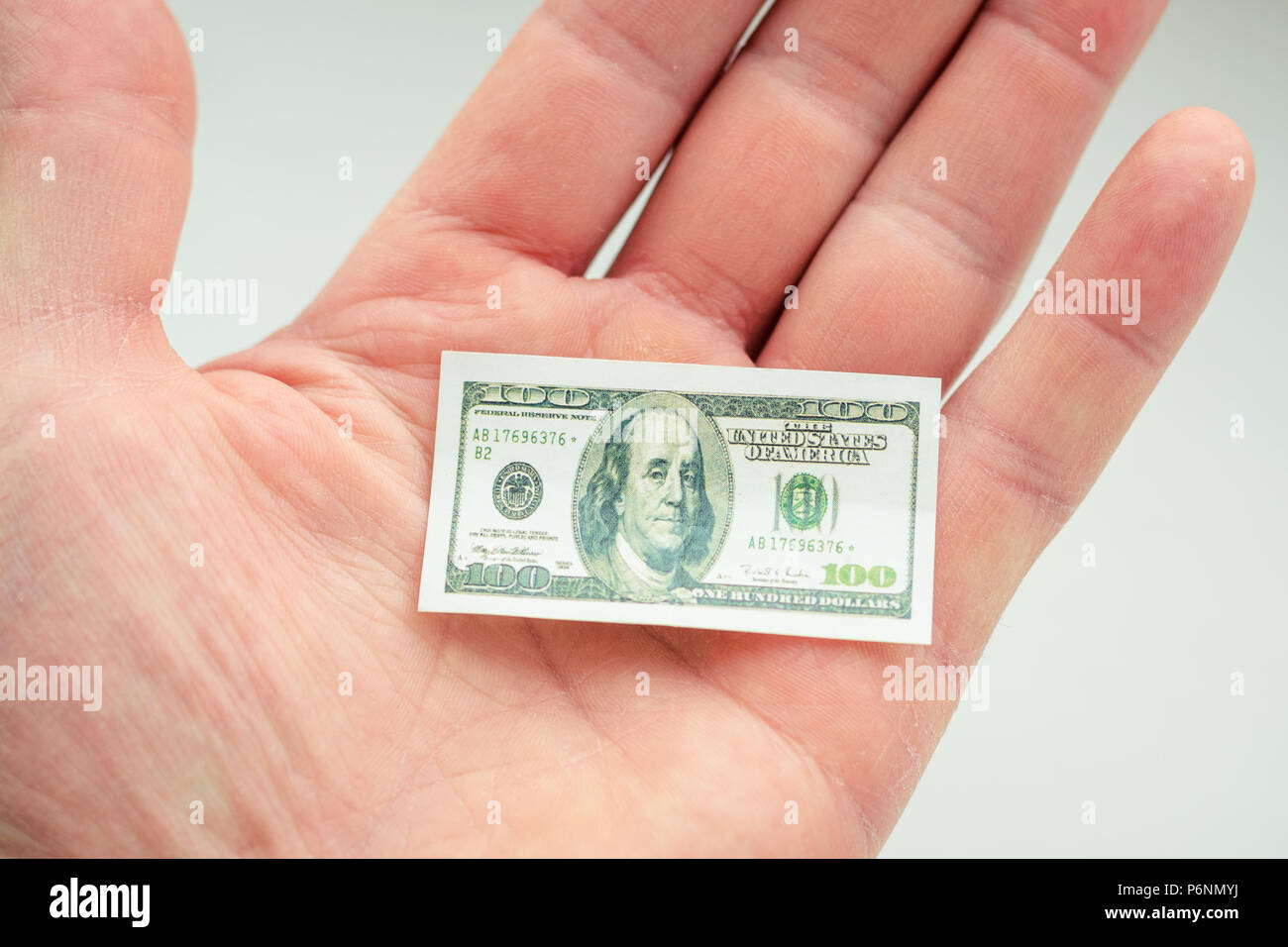 hand holding small banknote of US dollar, white background close up ...