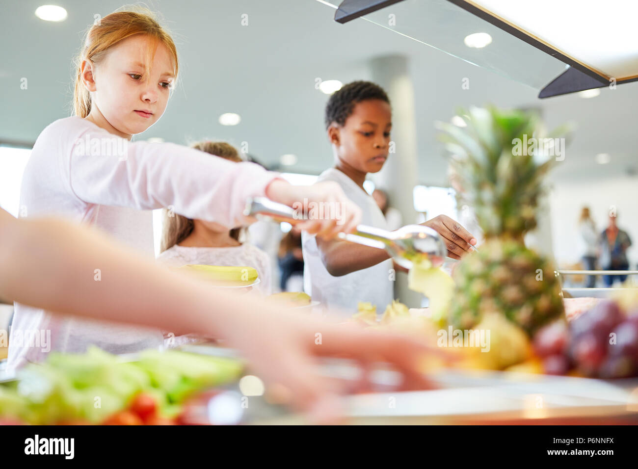 Students in elementary school take fruit at the buffet in the cafeteria ...