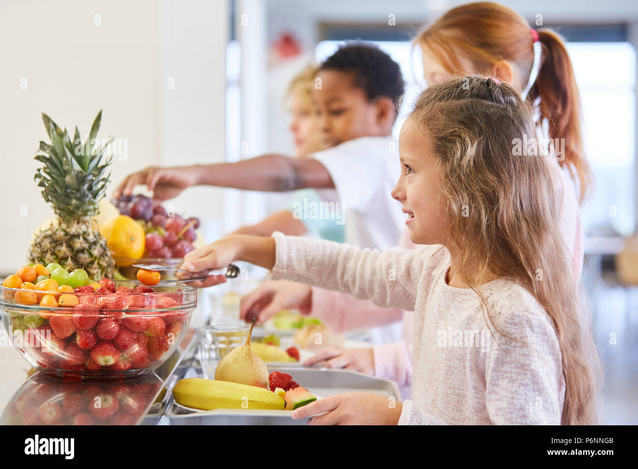 Girl and other kids at the fruit buffet at the cafeteria in elementary ...
