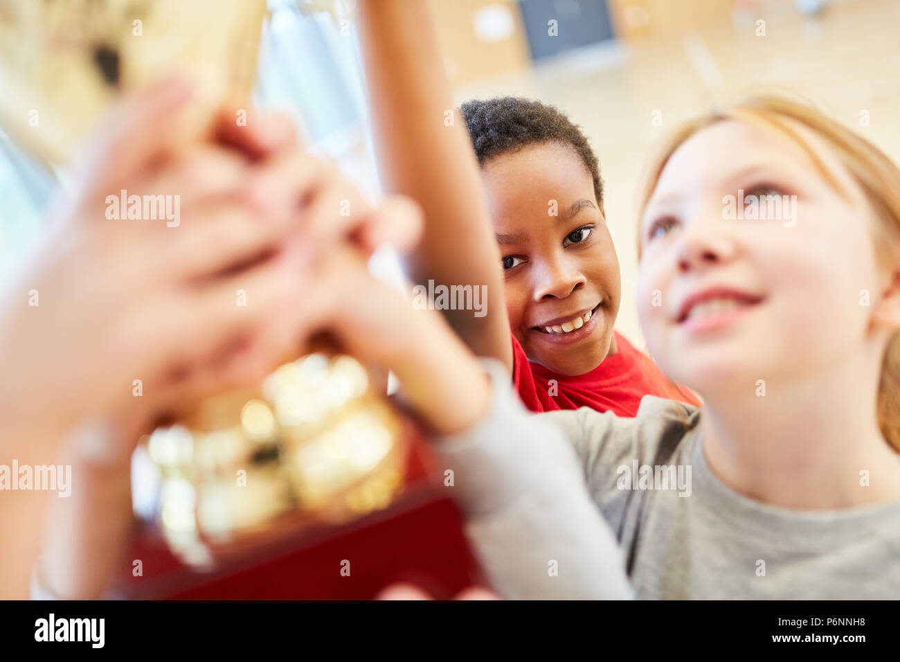 Children at an award ceremony with the trophy after a sports ...