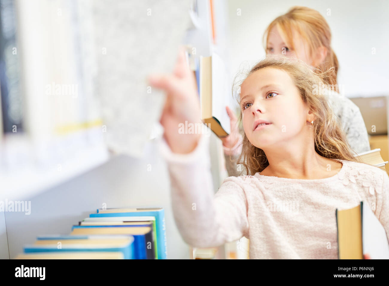Girls as students in the school's library are researching for a book ...