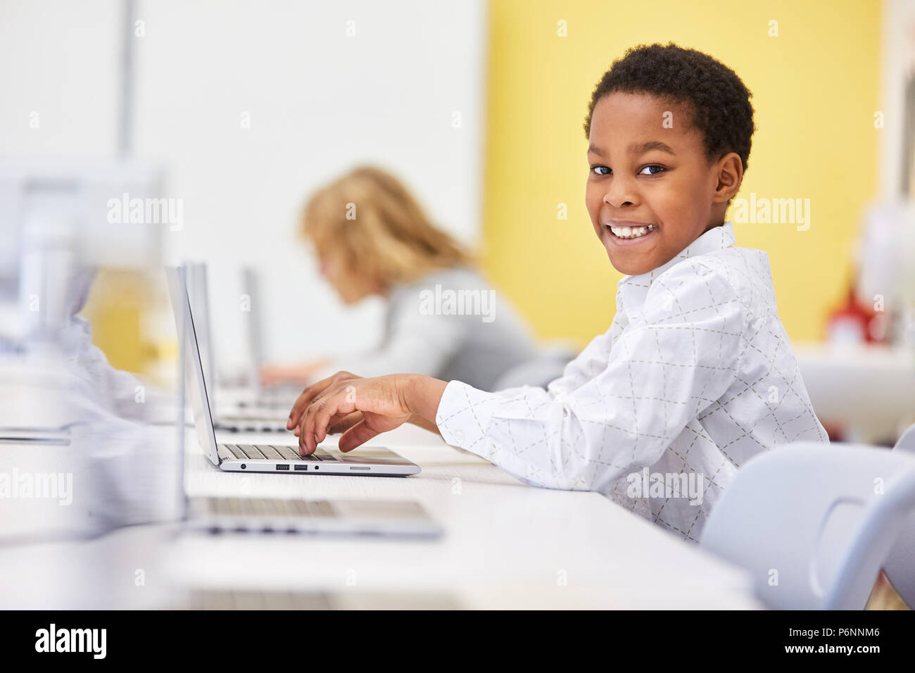 African boy learns computer science at laptop. Computer in elementary ...