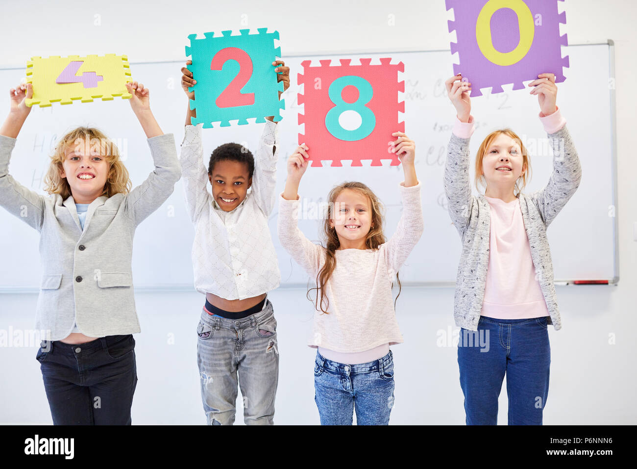 Children in elementary school hold up numbers signs as a teambuilding ...