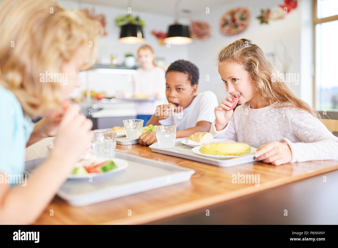 Children as students eat lunch together in the canteen of the school ...