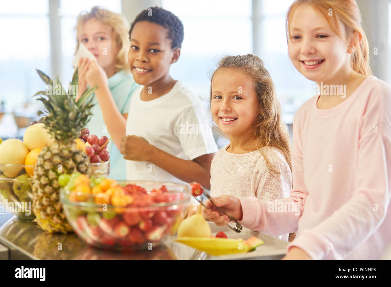 Multicultural group of children at the primary school buffet take ...