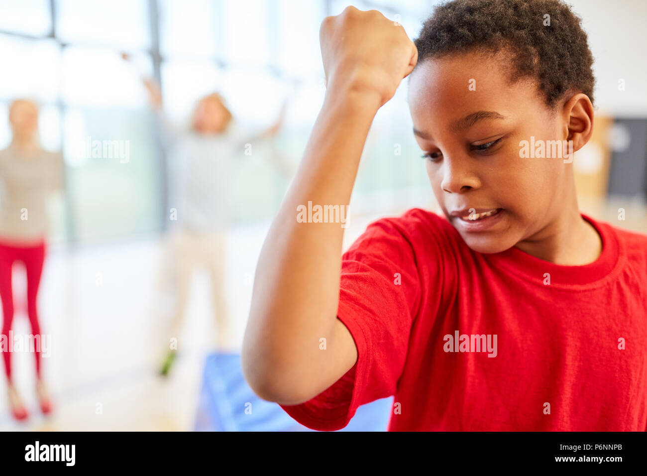 African boy is exercising his biceps in elementary school physical ...