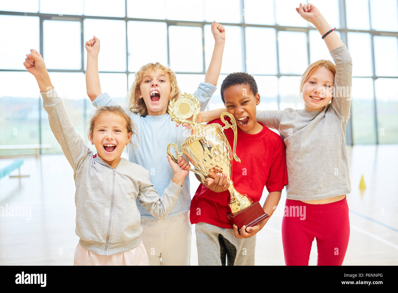 Cheering children as a successful student team with trophy after a ...