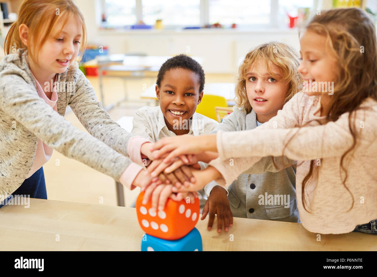 Children stack hands in multicultural school as an exercise for ...