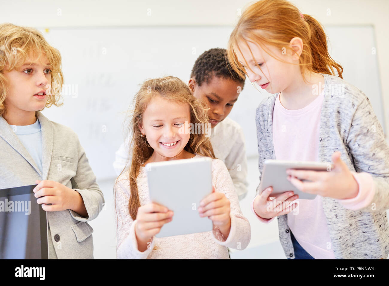 Group of kids in elementary school learn in teamwork with the tablet ...