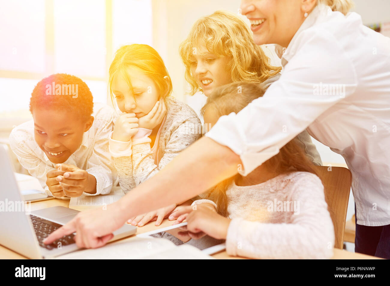 Group of pupils sits in front of laptop Computer with teacher in elementary school Stock Photo ...