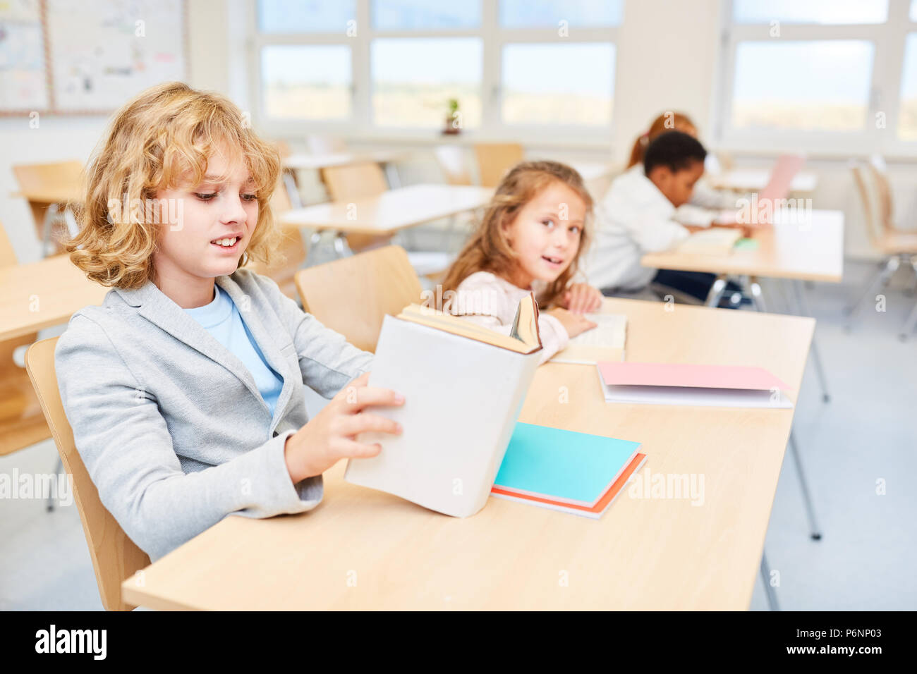 Children as elementary school students learn together in the classroom ...