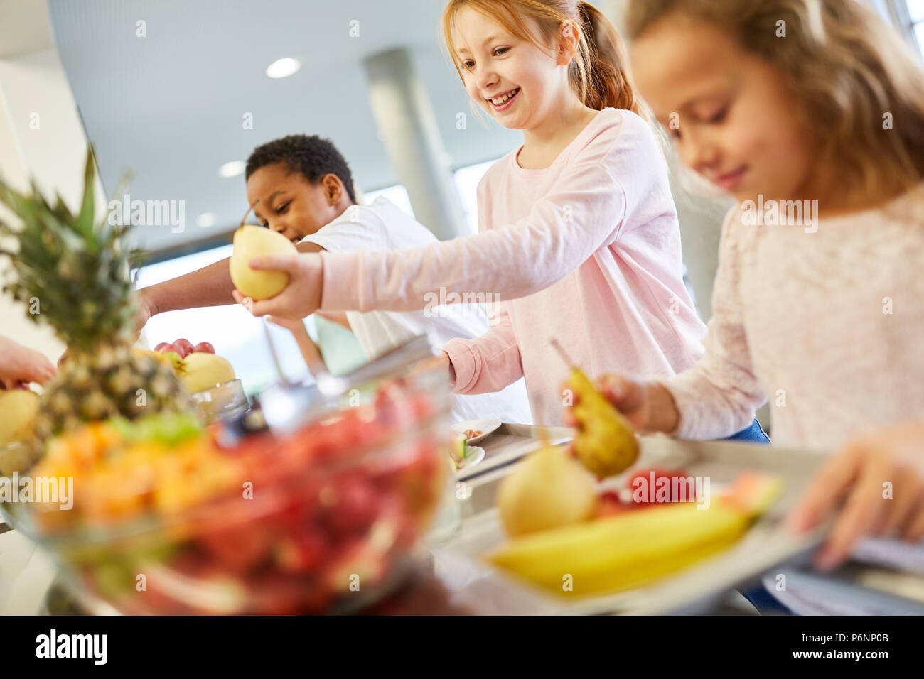 Students in elementary school get fresh fruit at the cafeteria's buffet ...