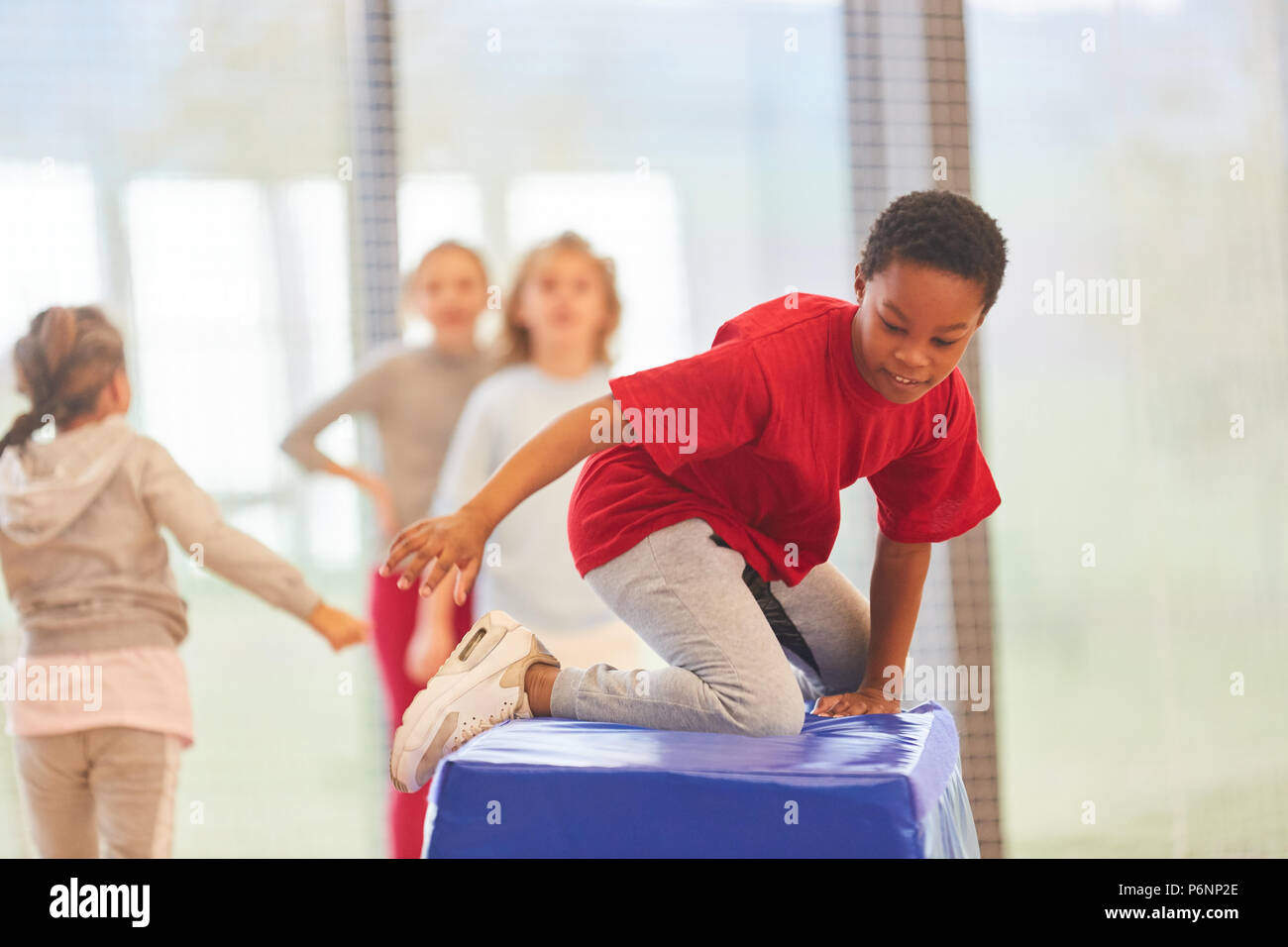 Children in elementary school physical education are doing gymnastics ...