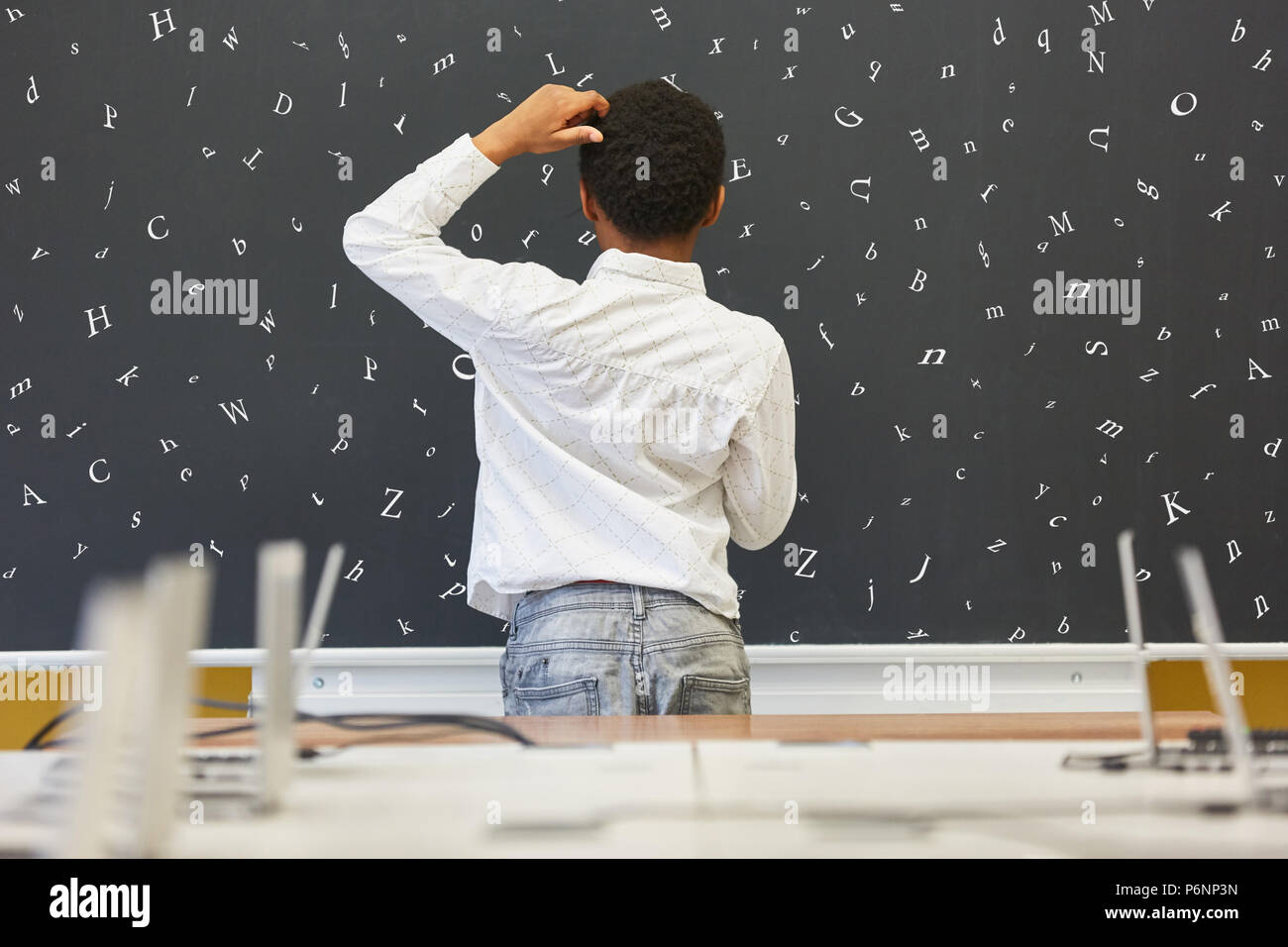 African student pensively stands in front of blackboard with many ...
