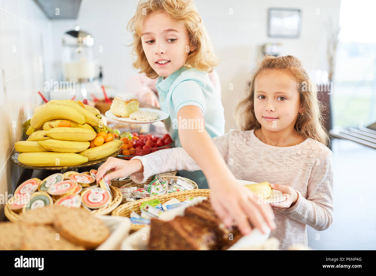 Students in elementary school take fruit at the buffet in the cafeteria ...