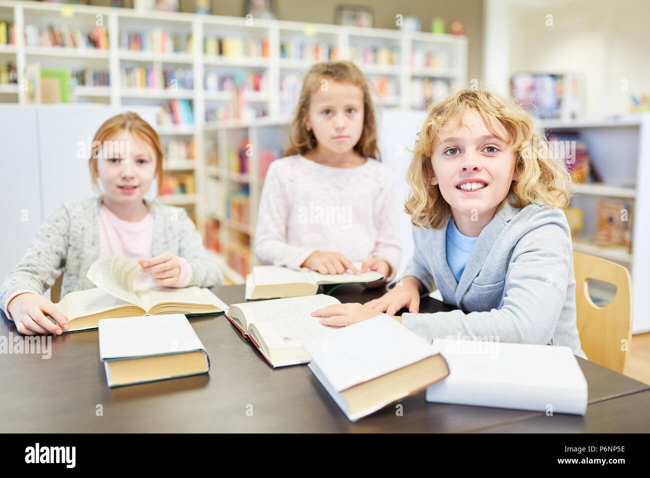 Group elementary school students learn together as a team in the ...