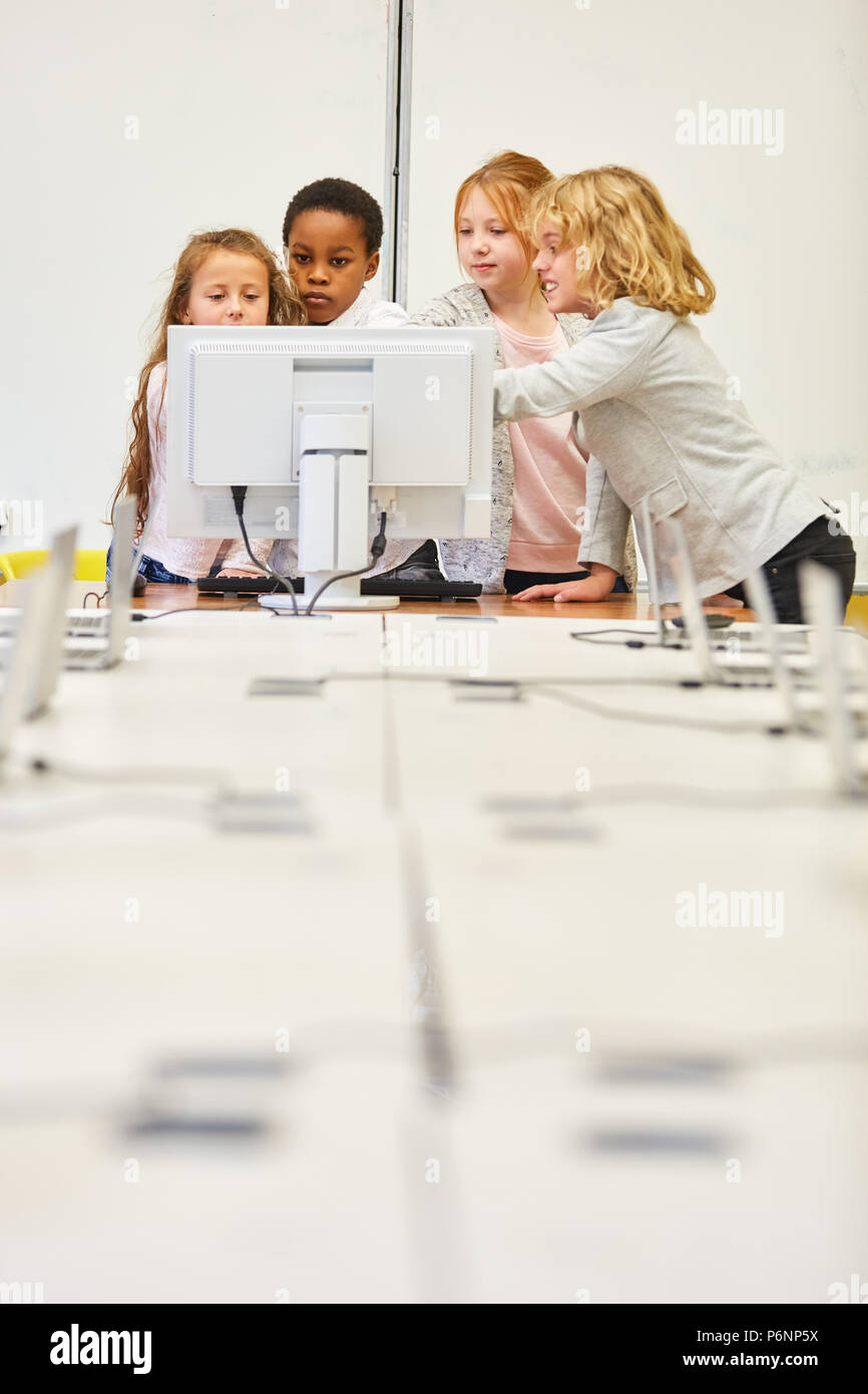 Group of children learns together at the computer in the computer ...