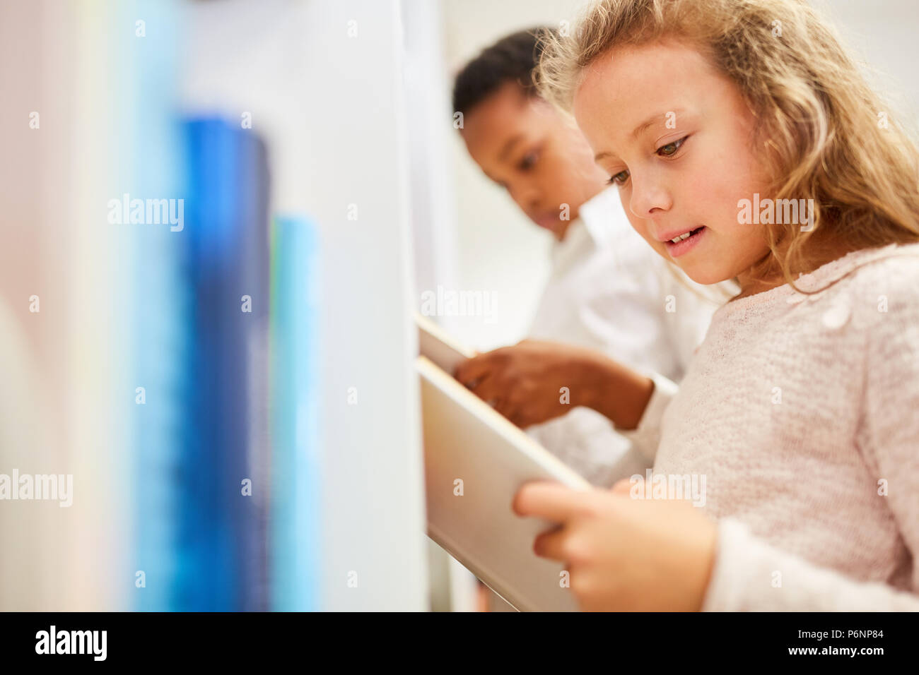 Children in elementary school reading and researching in books Stock ...
