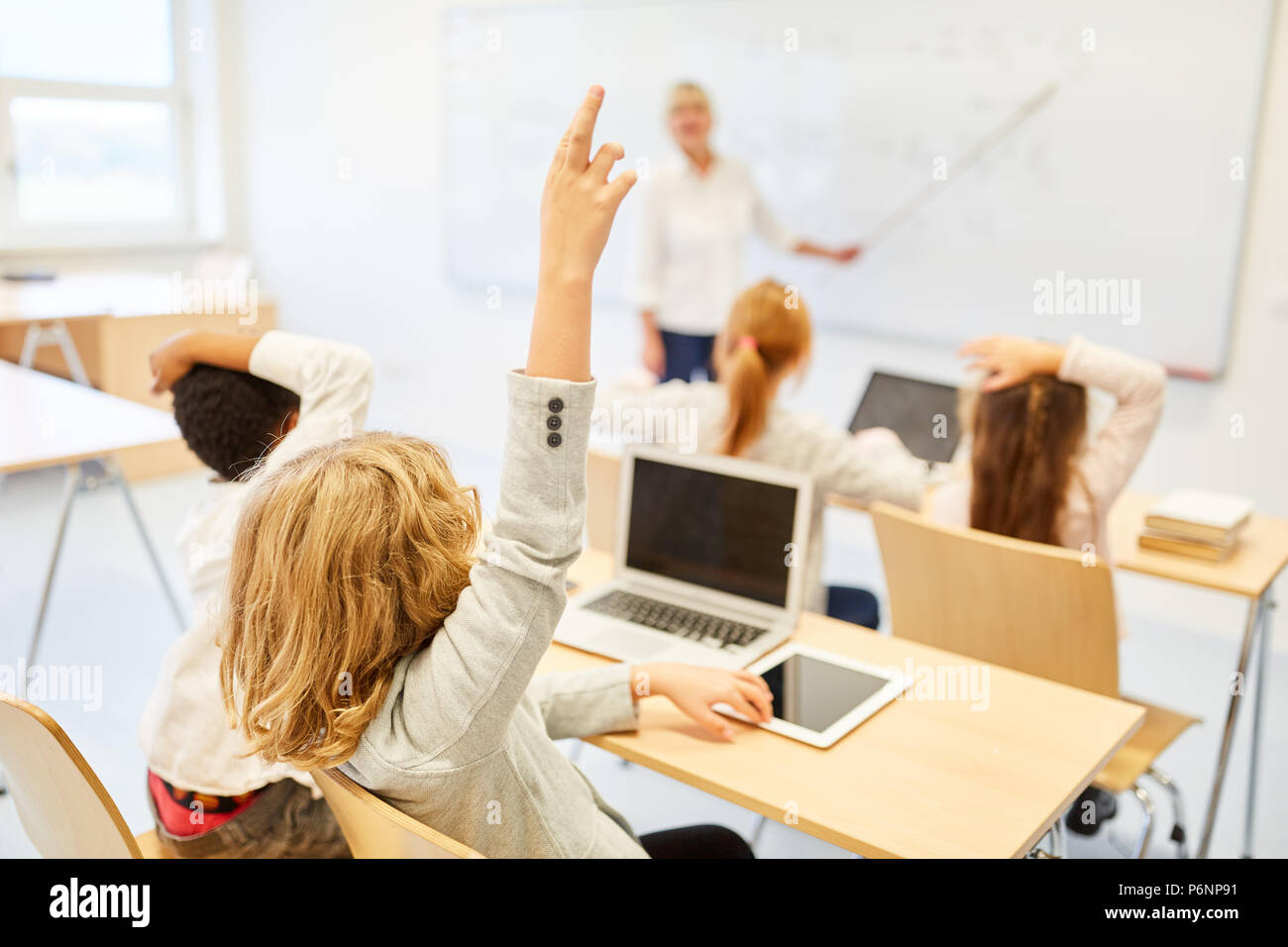 Children of a primary school in the computer lesson with teacher in the ...