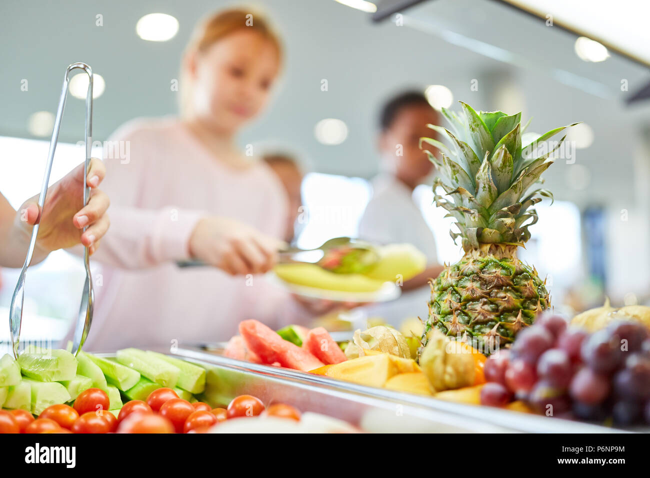 Students in elementary school get fresh fruit at the buffet in the ...