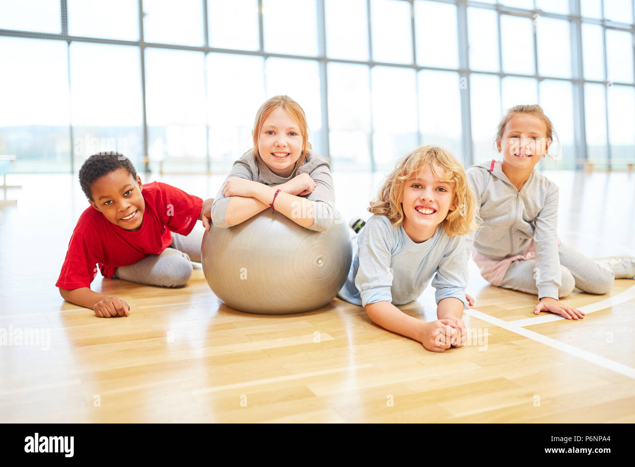 Group of kids in elementary school physical education with a gym ball ...