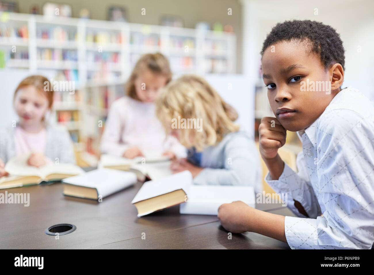 Thoughtful student in the library does homework with his study group ...