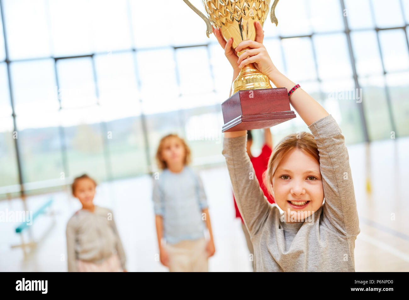 Happy girl proudly holds up the trophy at the award ceremony in school ...
