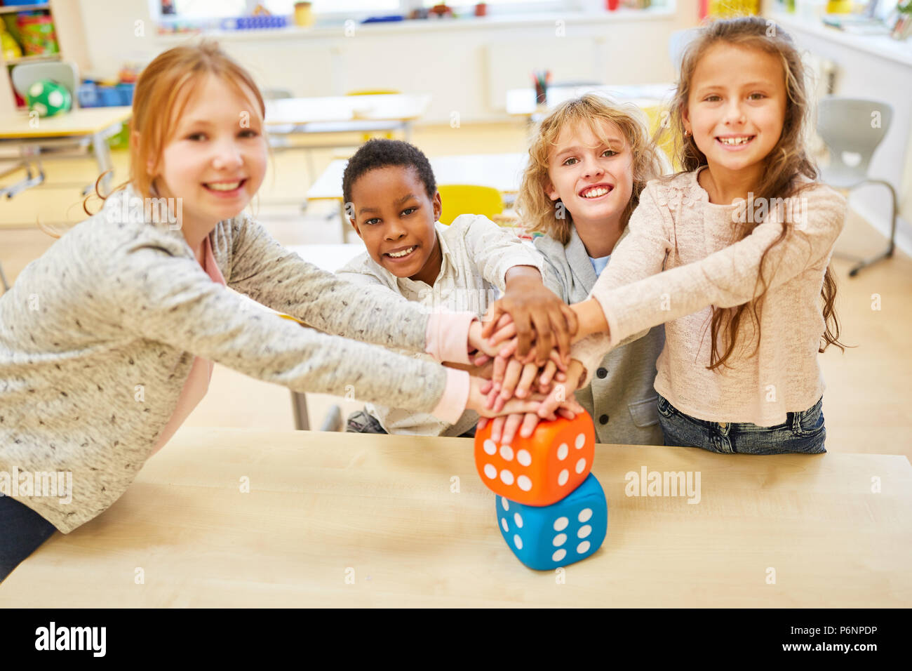 Children in elementary school do a teambuilding exercise and stack ...