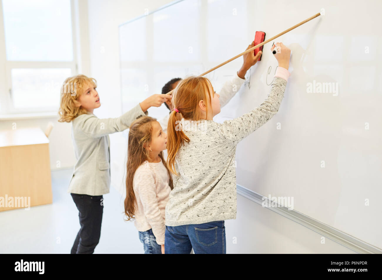Children as students solve a math task on the blackboard in teamwork ...