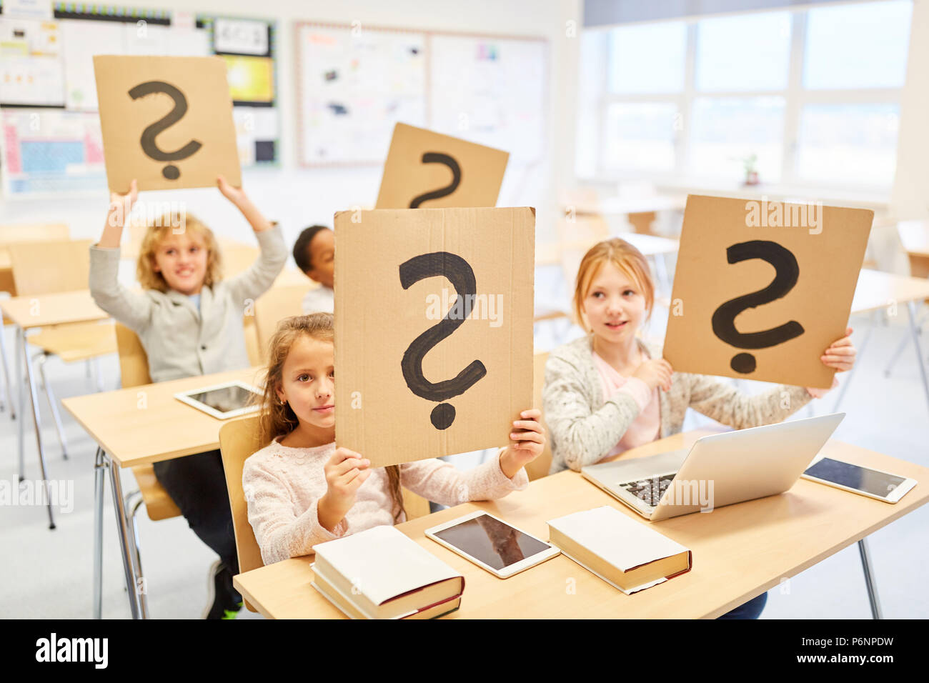 Children in the class of a primary school with question marks for ...