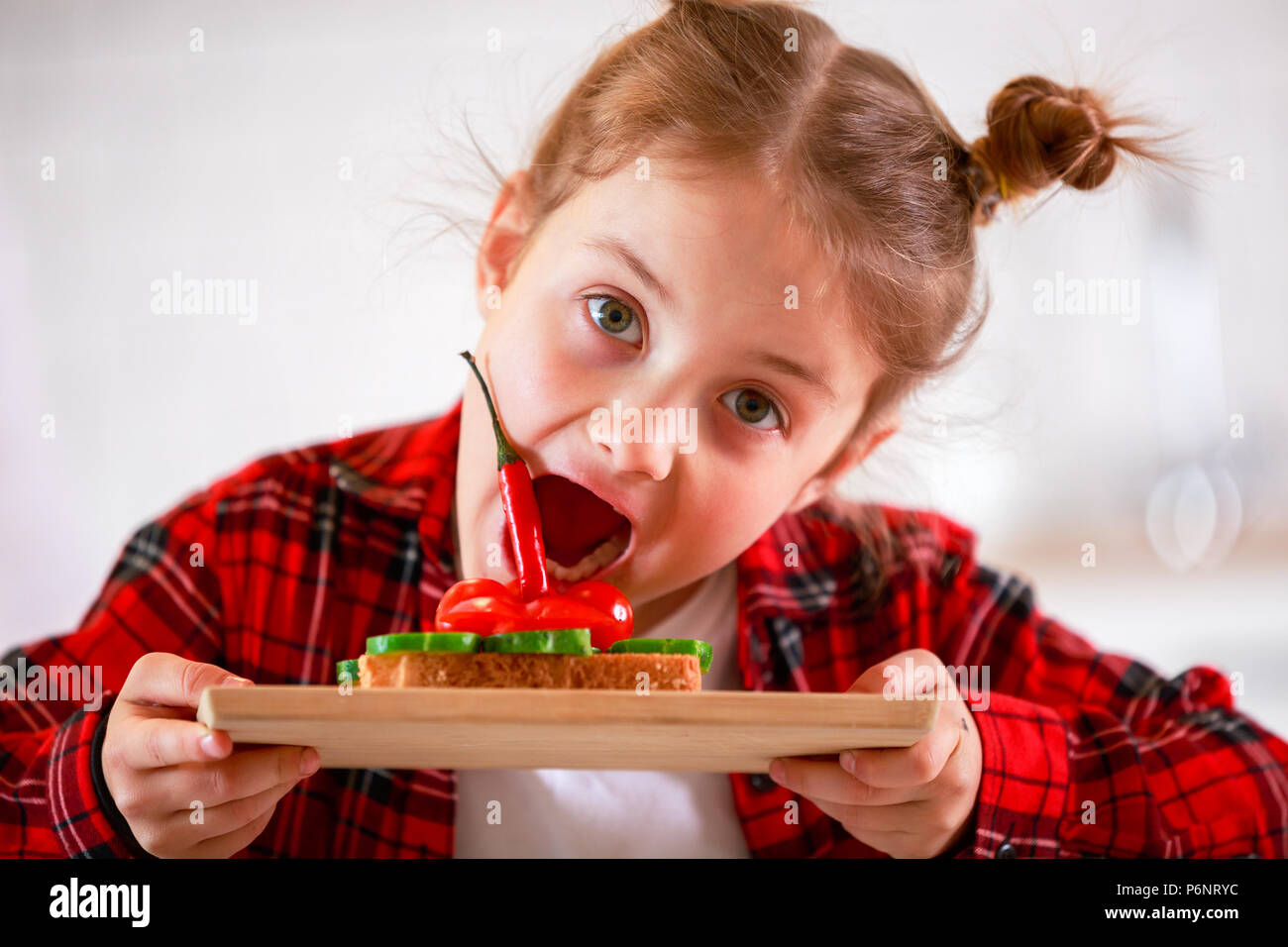 Photo of little girl biting sandwich on white background Stock Photo ...