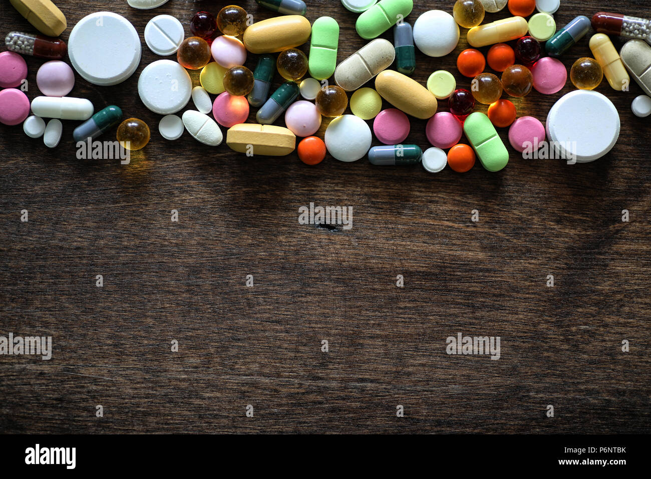 Medical background of various colorful medications on a textured wooden ...