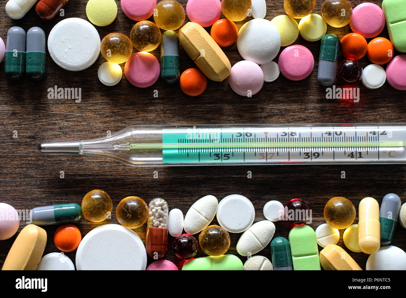 Medical background of various colorful medications on a textured wooden ...