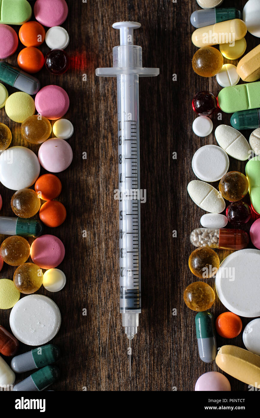 Medical background of various colorful medications on a textured wooden ...