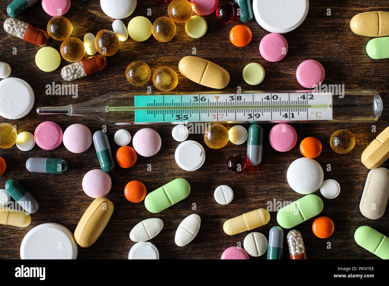 Medical background of various colorful medications on a textured wooden ...