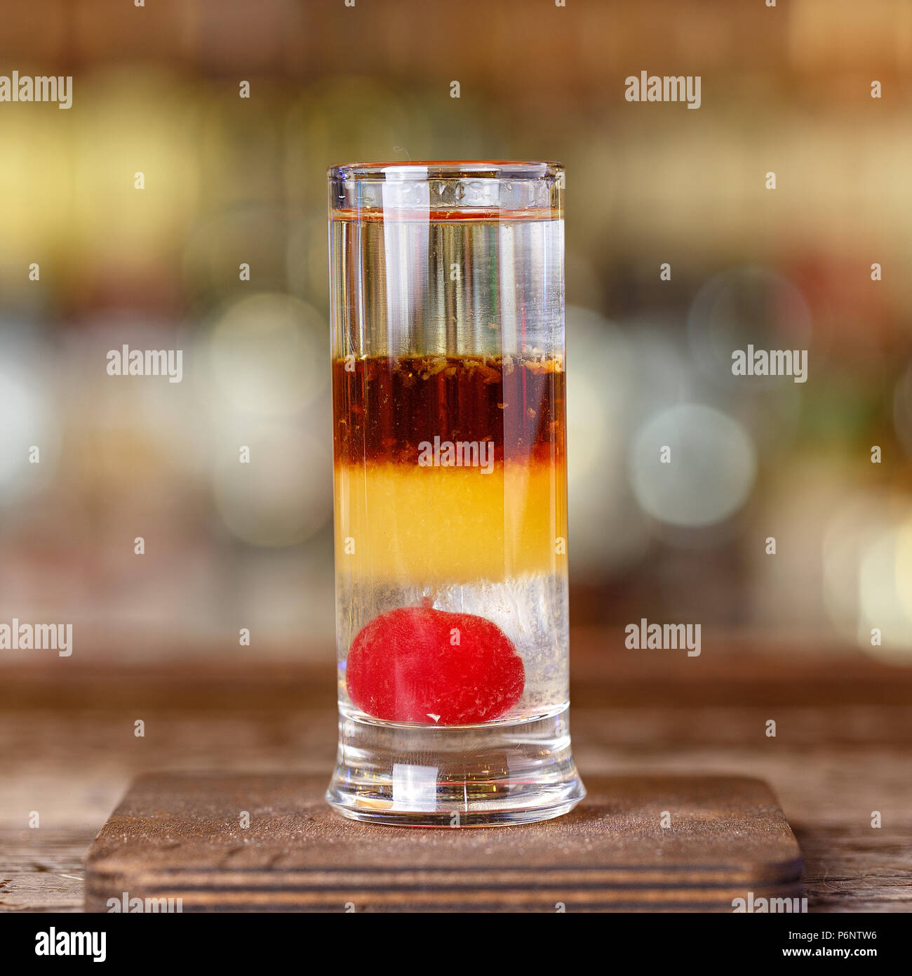 Multilayer multicolored cocktail on the bar in the nightclub ...