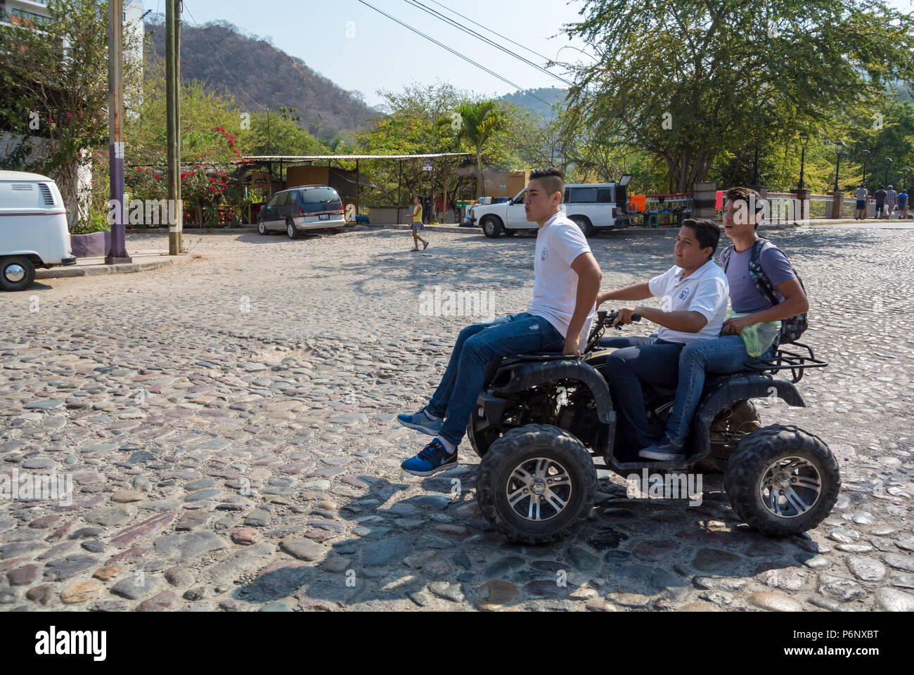 A group of young Mexican men riding on quad bike, puerto vallarta ...