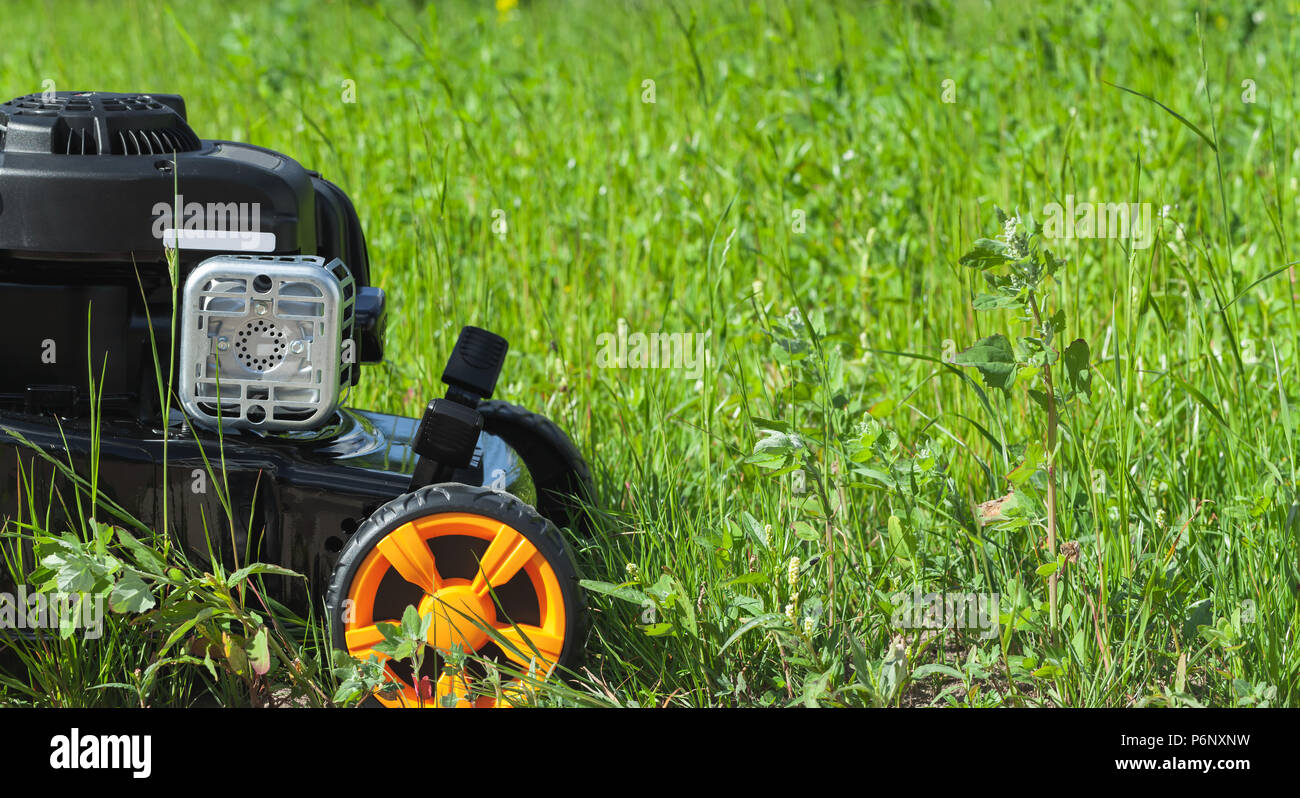 Lawn mower or grass cutter stands on fresh green lawn, closeup photo ...