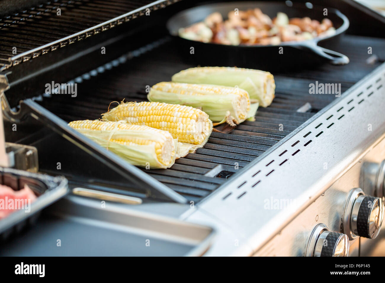 Step by step. Grilling fresh corn on outdoor gas grill Stock Photo - Alamy
