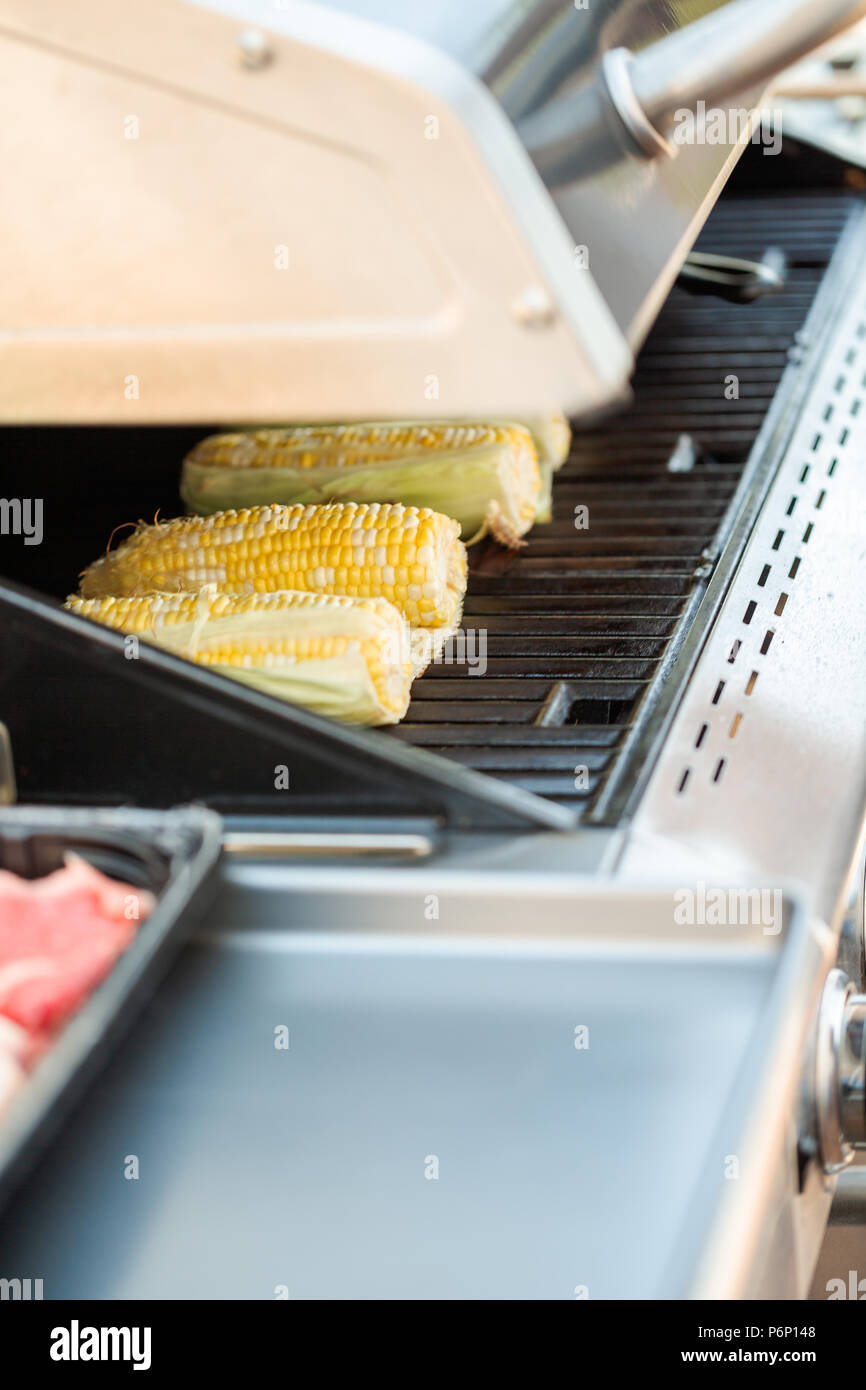 Step by step. Grilling fresh corn on outdoor gas grill Stock Photo - Alamy