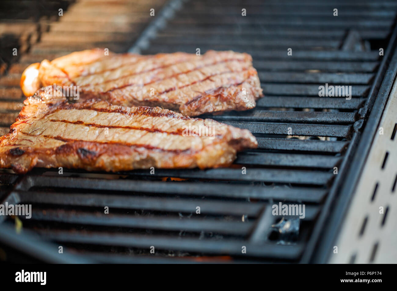 Step by step. Grilling New York strip steak on outdoor gas grill Stock ...