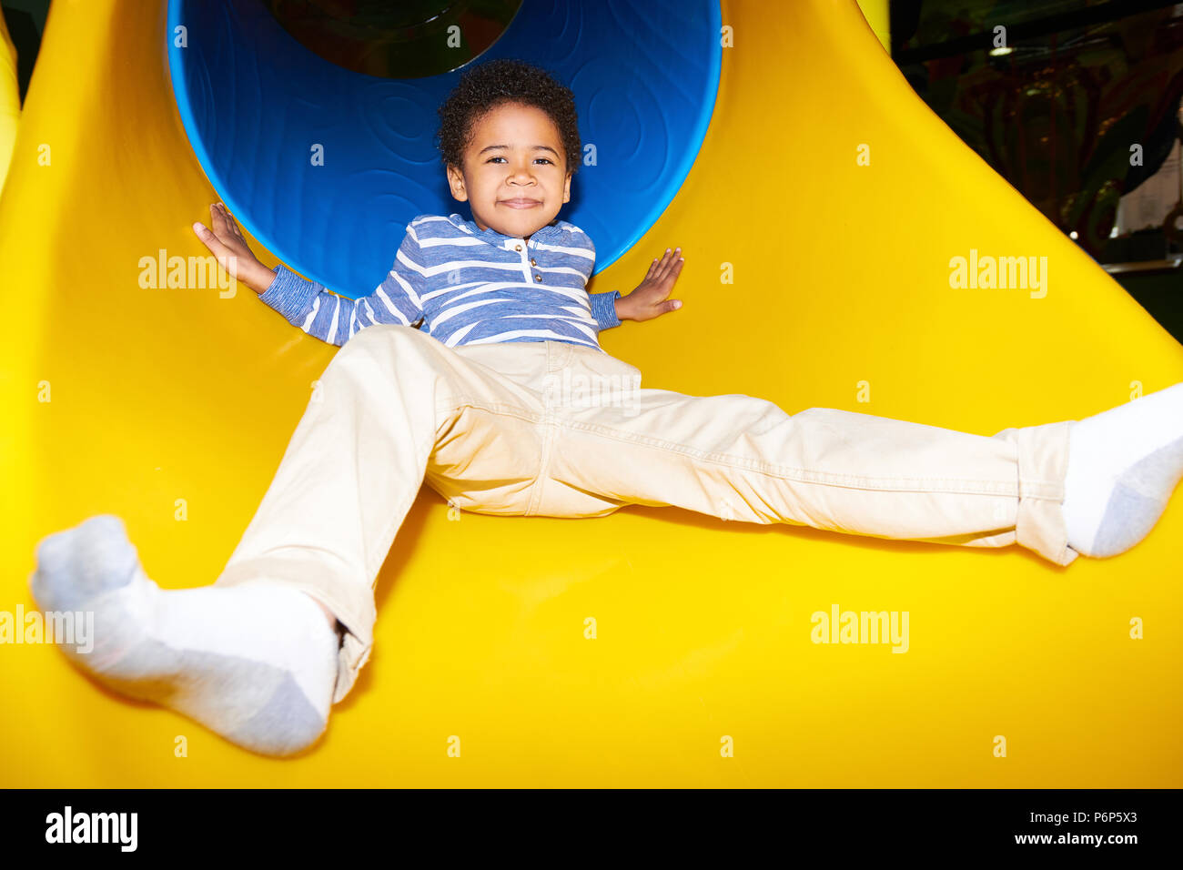 Happy Kid Going Down Slide Stock Photo - Alamy