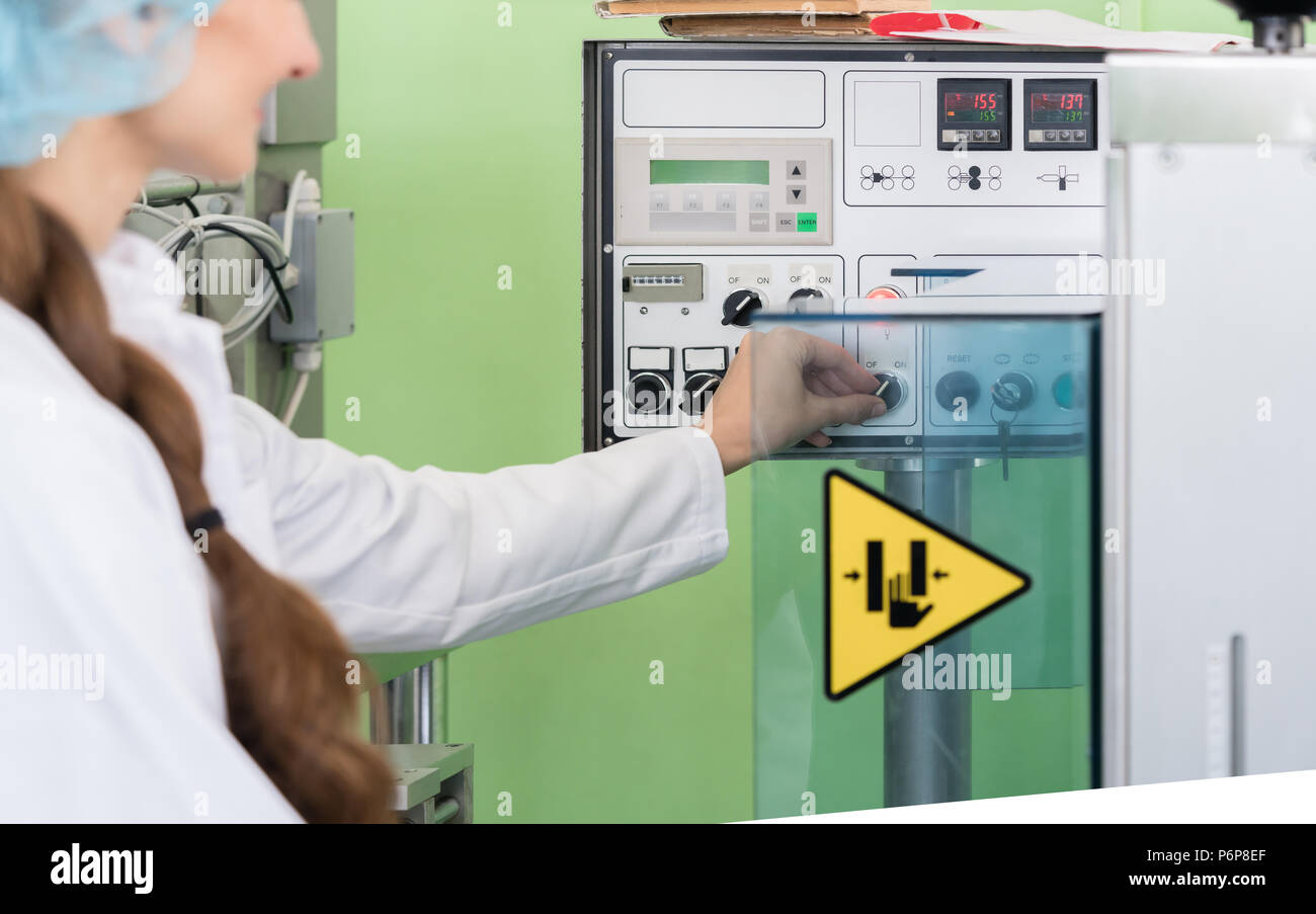 Woman manufacturing engineer adjusting the settings of an industrial ...