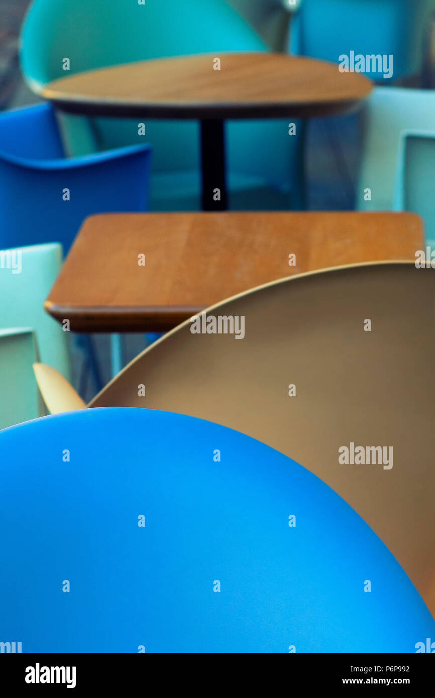 Multicolored plastic chairs and empty table in a summer street cafe ...