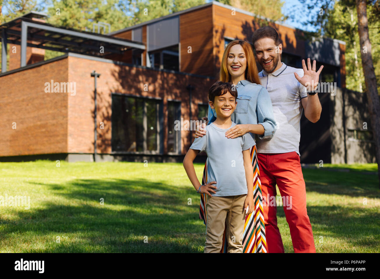 Content parents standing with their son Stock Photo - Alamy