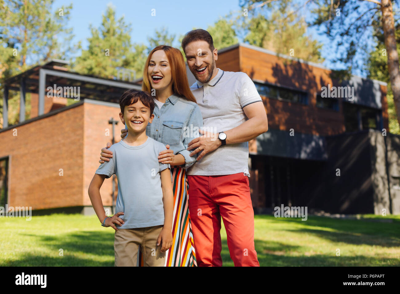 Pleased parents standing with their son Stock Photo - Alamy