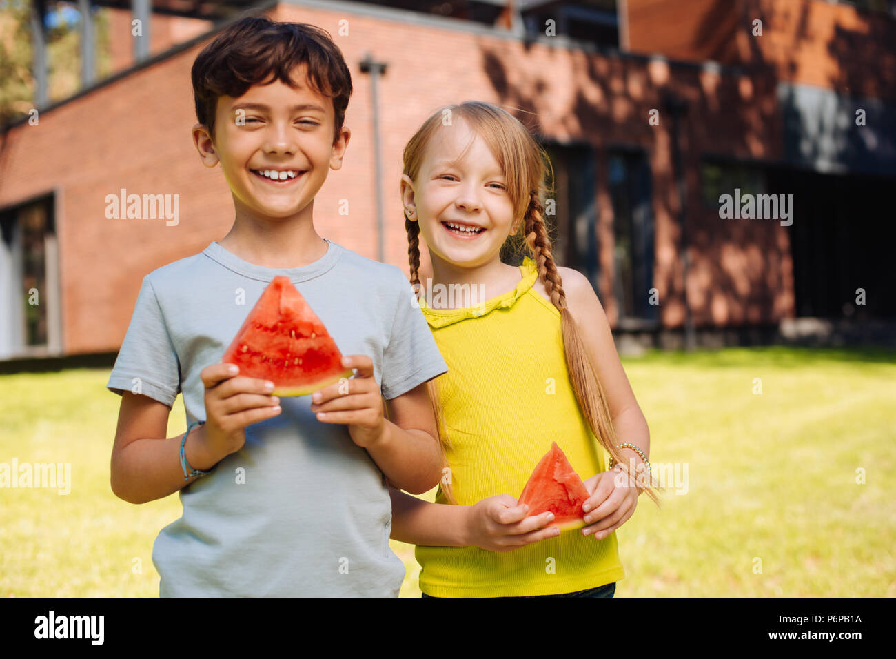 Exuberant children eating a ripe watermelon Stock Photo - Alamy