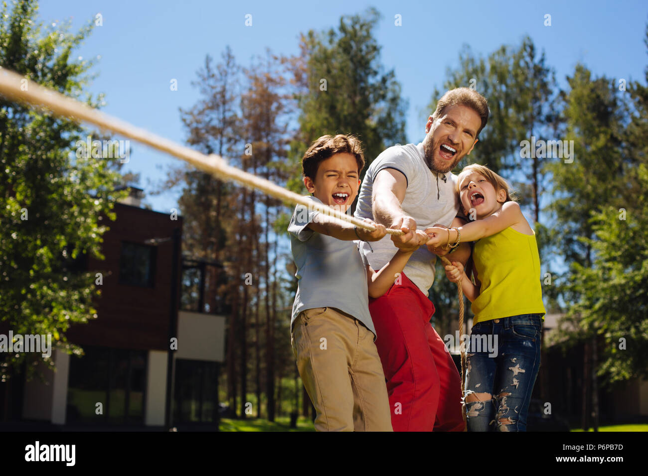 Inspired daddy doing a rope pulling Stock Photo - Alamy