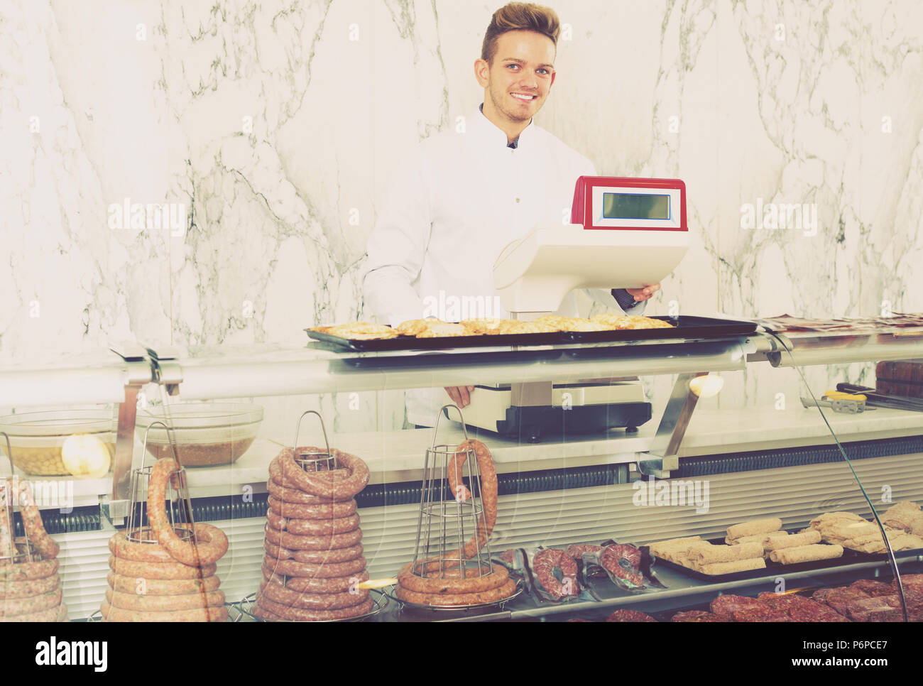 Happy seller in his grocery shop welcoming customers Stock Photo - Alamy