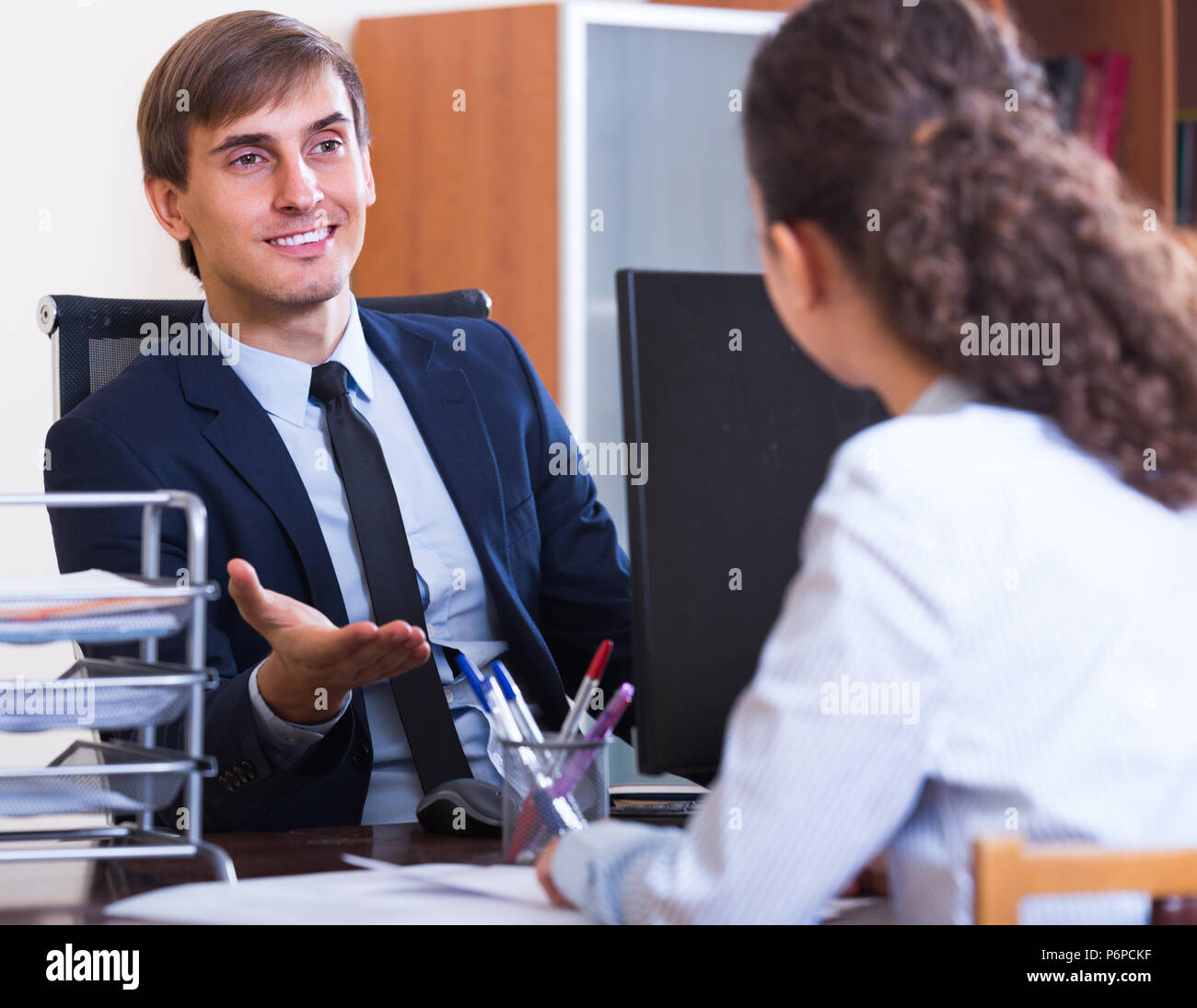 Young professional teaching new employee in practice at workplace Stock ...